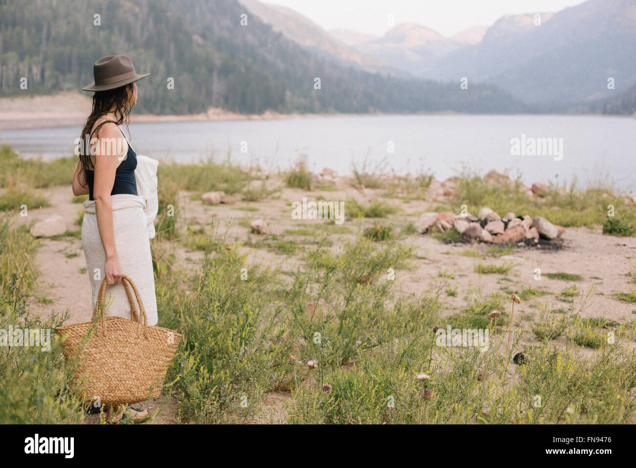 A woman wrapped in a towel walking along a path by a lake Stock Photo ...