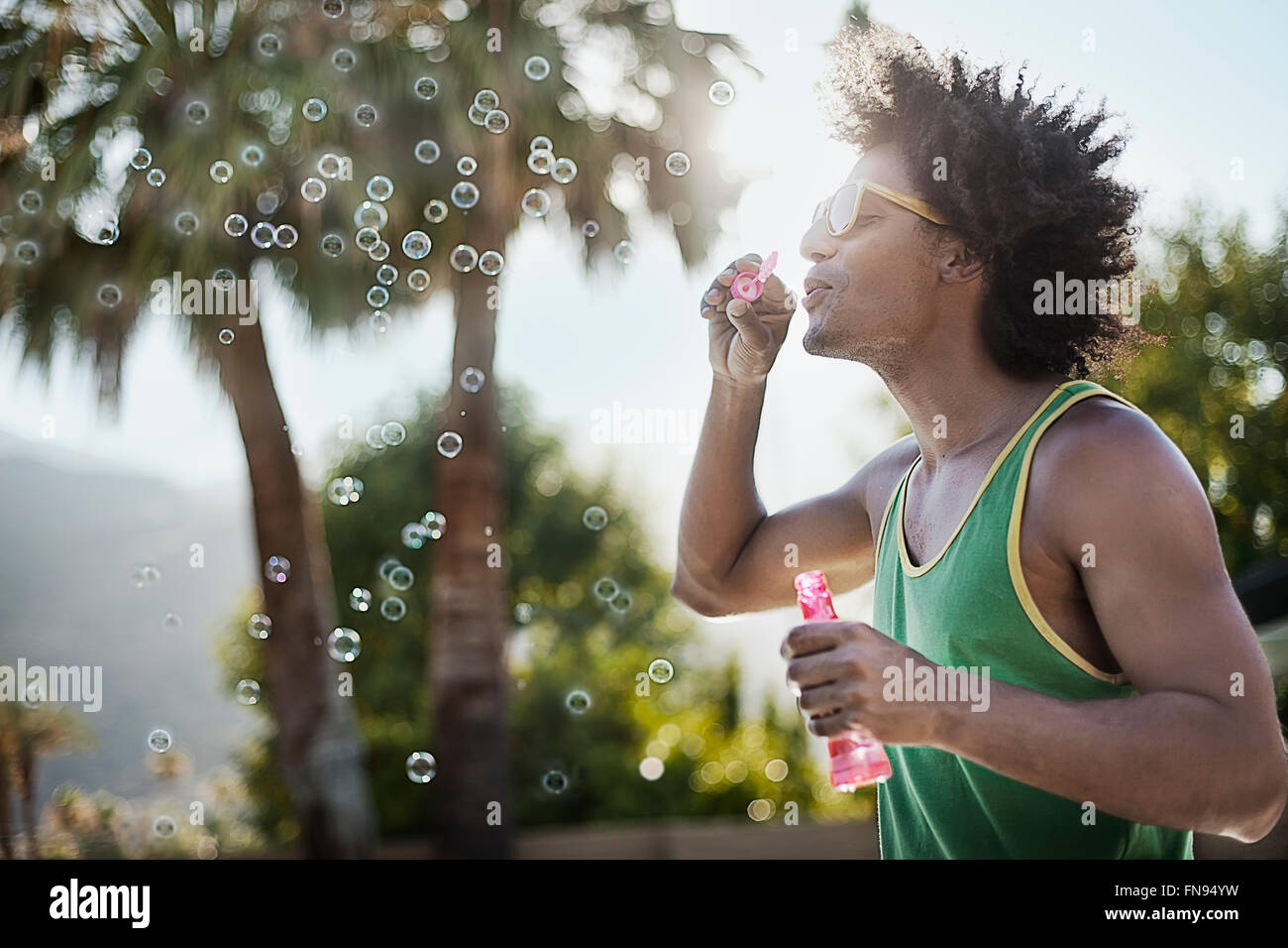 A young man blowing bubbles using a bubble wand Stock Photo - Alamy