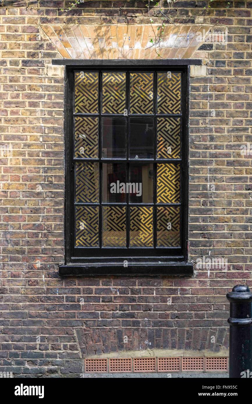 Exterior of Georgian sash window decorated with gold patterns set in a ...