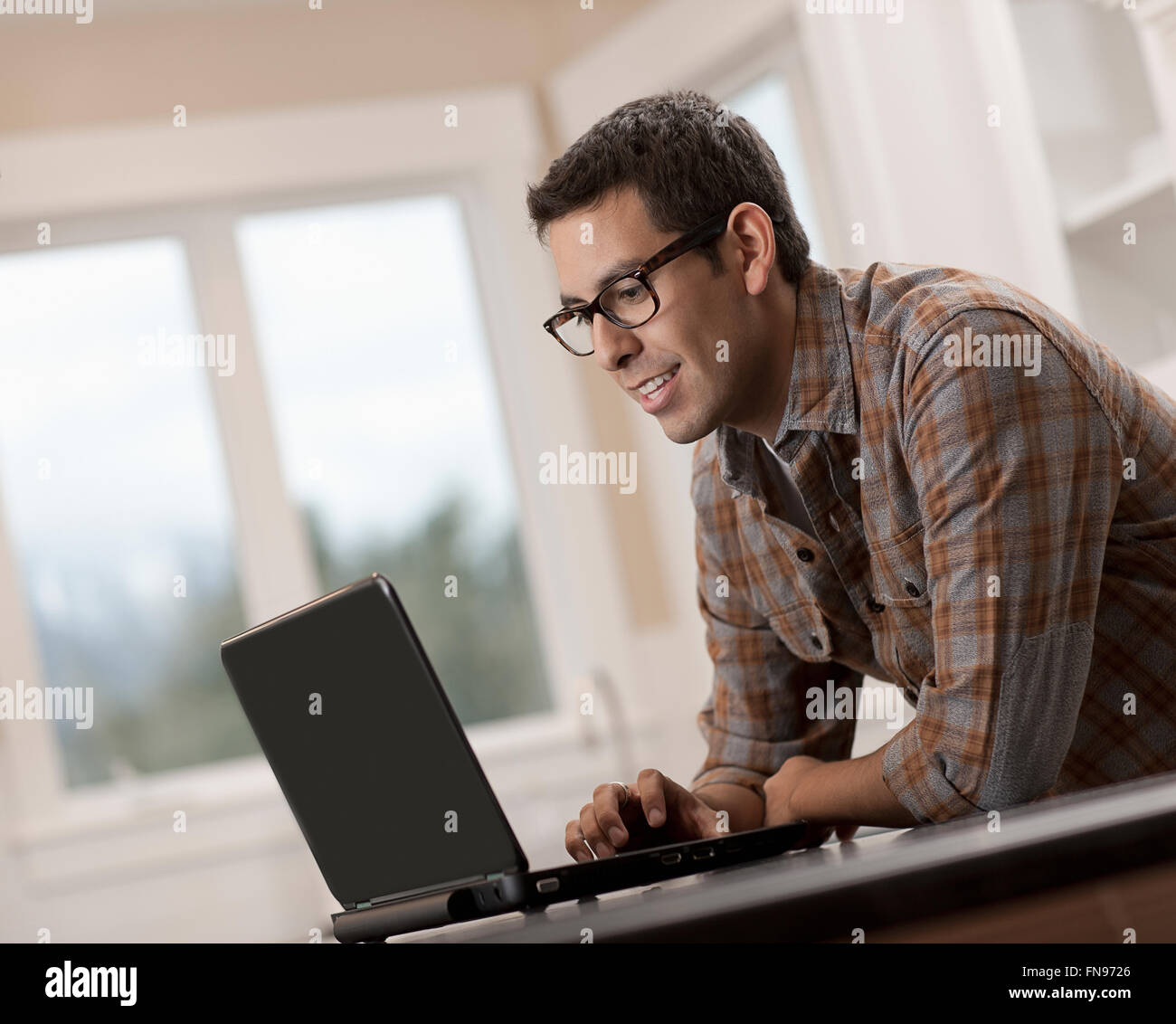 A man sitting using a laptop computer Stock Photo - Alamy