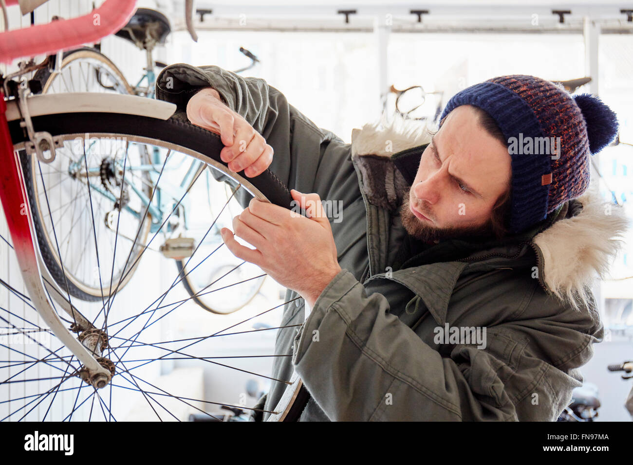 A young man working in a cycle shop, repairing a bicycle Stock Photo ...