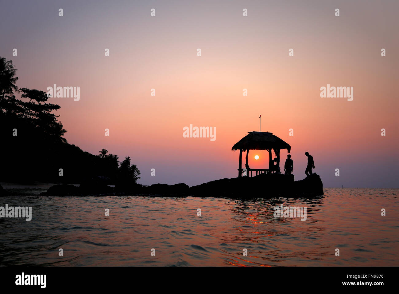 Silhouette of three people on beach at sunset Stock Photo - Alamy