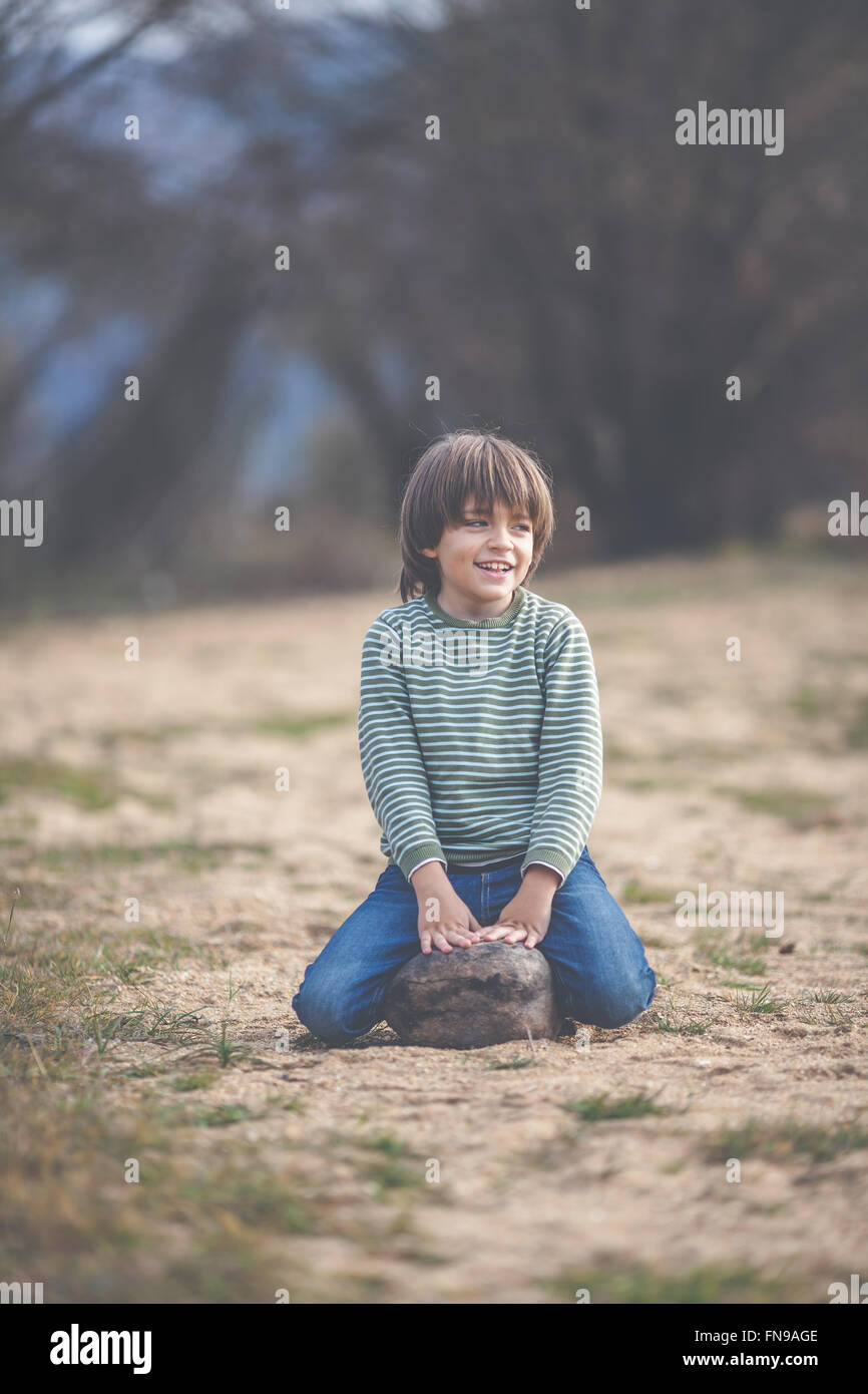 Boy sitting on a rock hi-res stock photography and images - Alamy