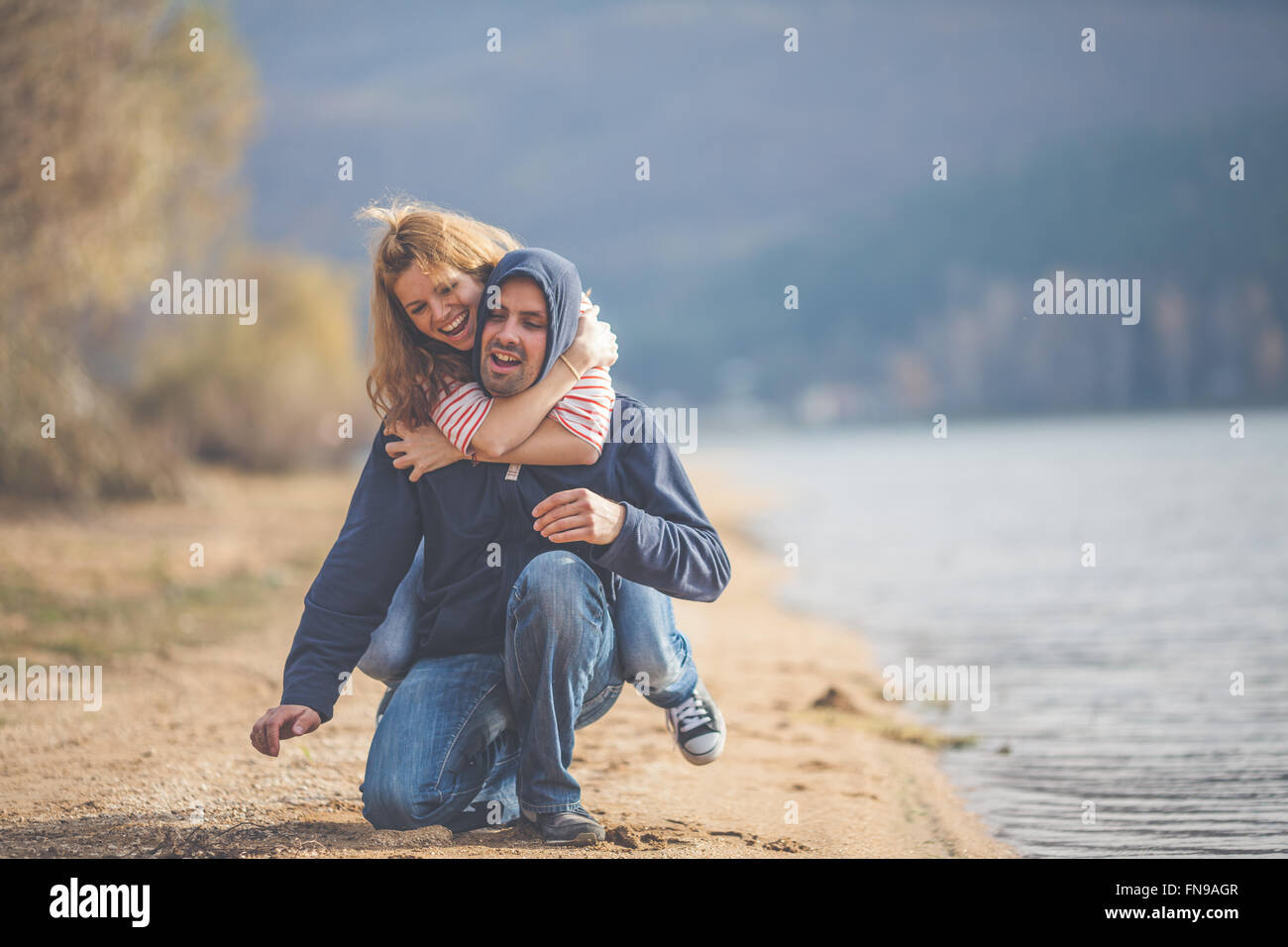 Man giving woman piggyback ride Stock Photo - Alamy
