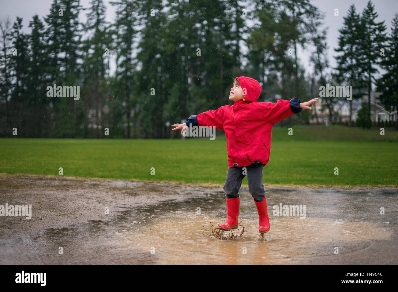 Boy jumping in puddle hi-res stock photography and images - Alamy