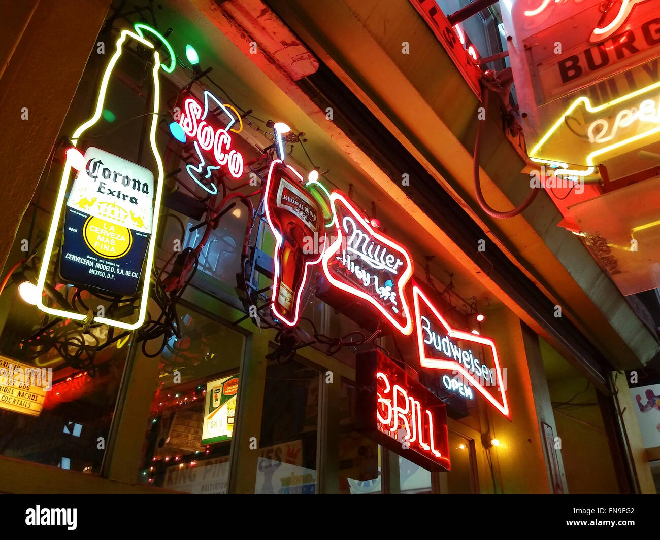 Illuminated neon signs advertising various brands of beer and liquor ...