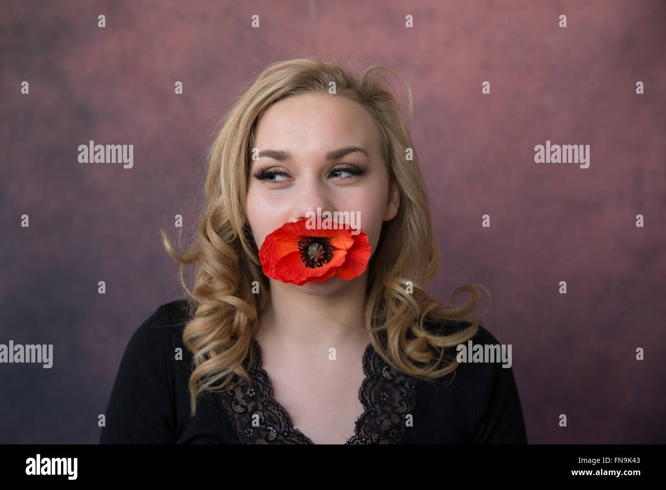 Portrait of a teenage girl with a poppy flower in her mouth Stock Photo ...