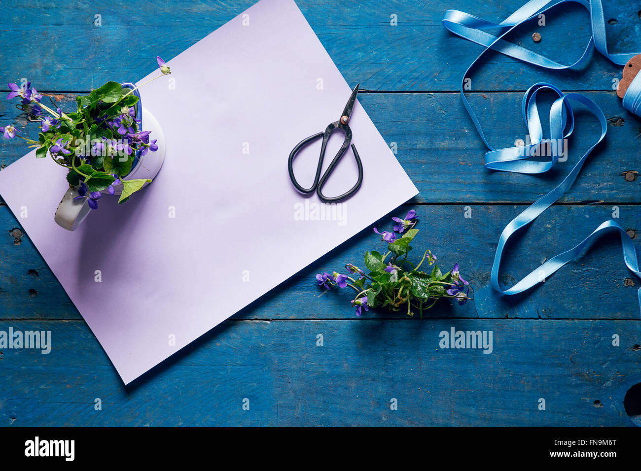 Spring flowers, ribbon, scissors and paper on table Stock Photo - Alamy