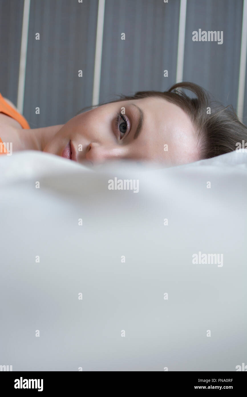 Young woman in bed alone Stock Photo - Alamy