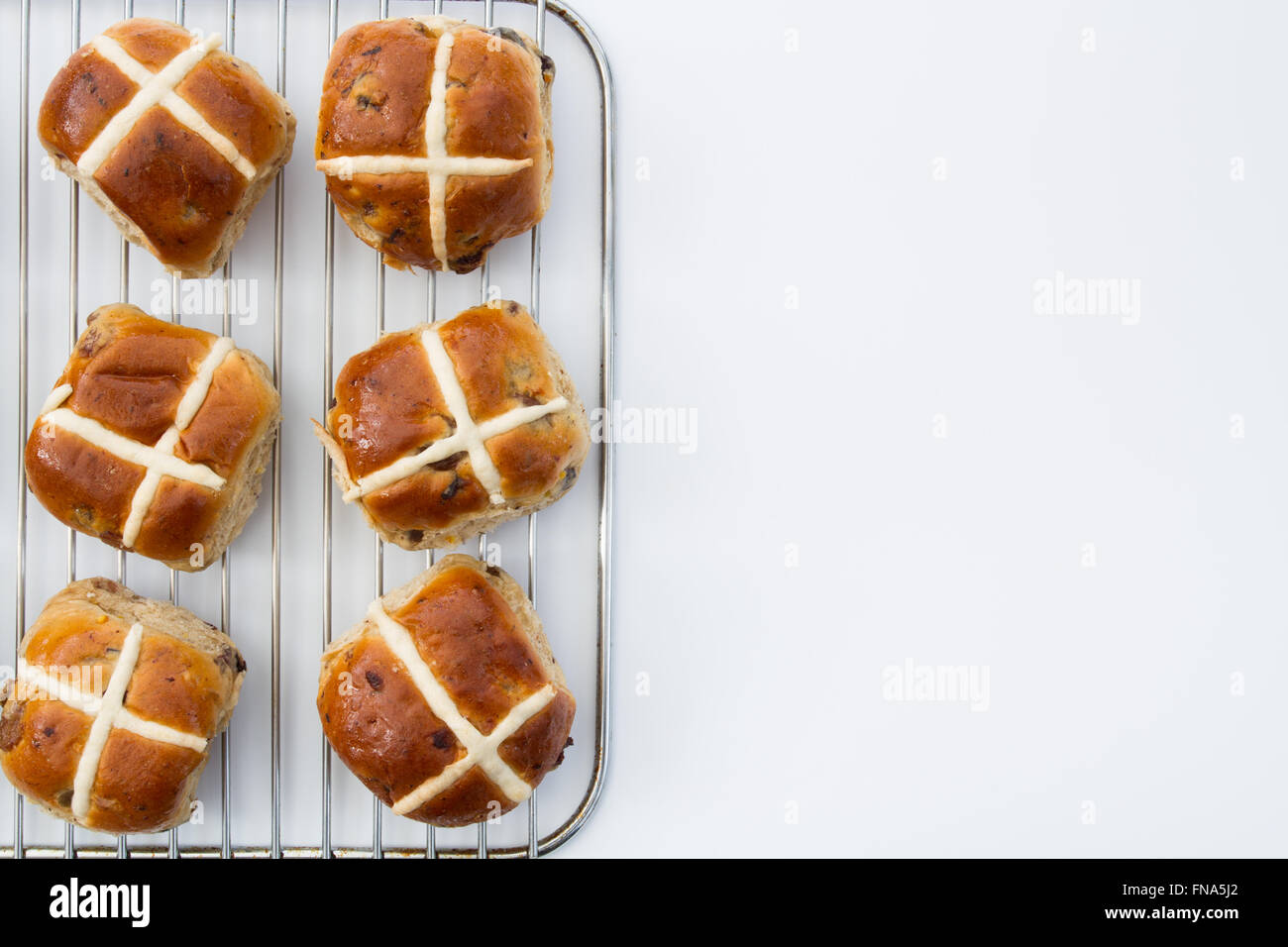 Freshly baked Easter, hot cross buns on an isolated white background ...