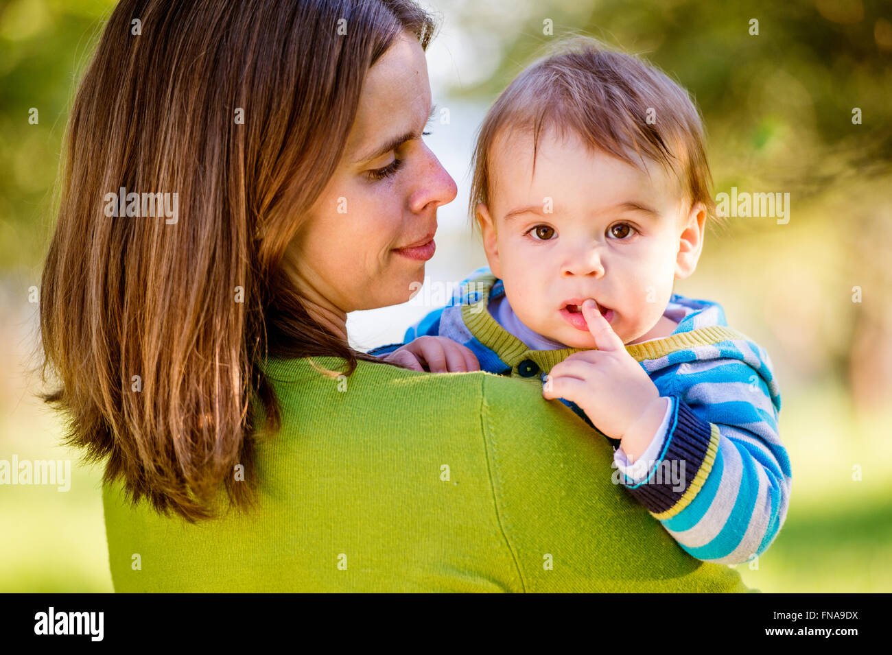 Mother holding little son in her arms, sunny nature Stock Photo - Alamy