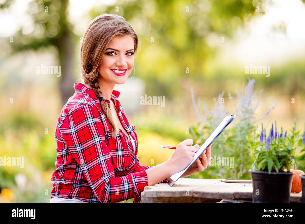 Gardener holding clipboard, at the table, green sunny nature Stock ...