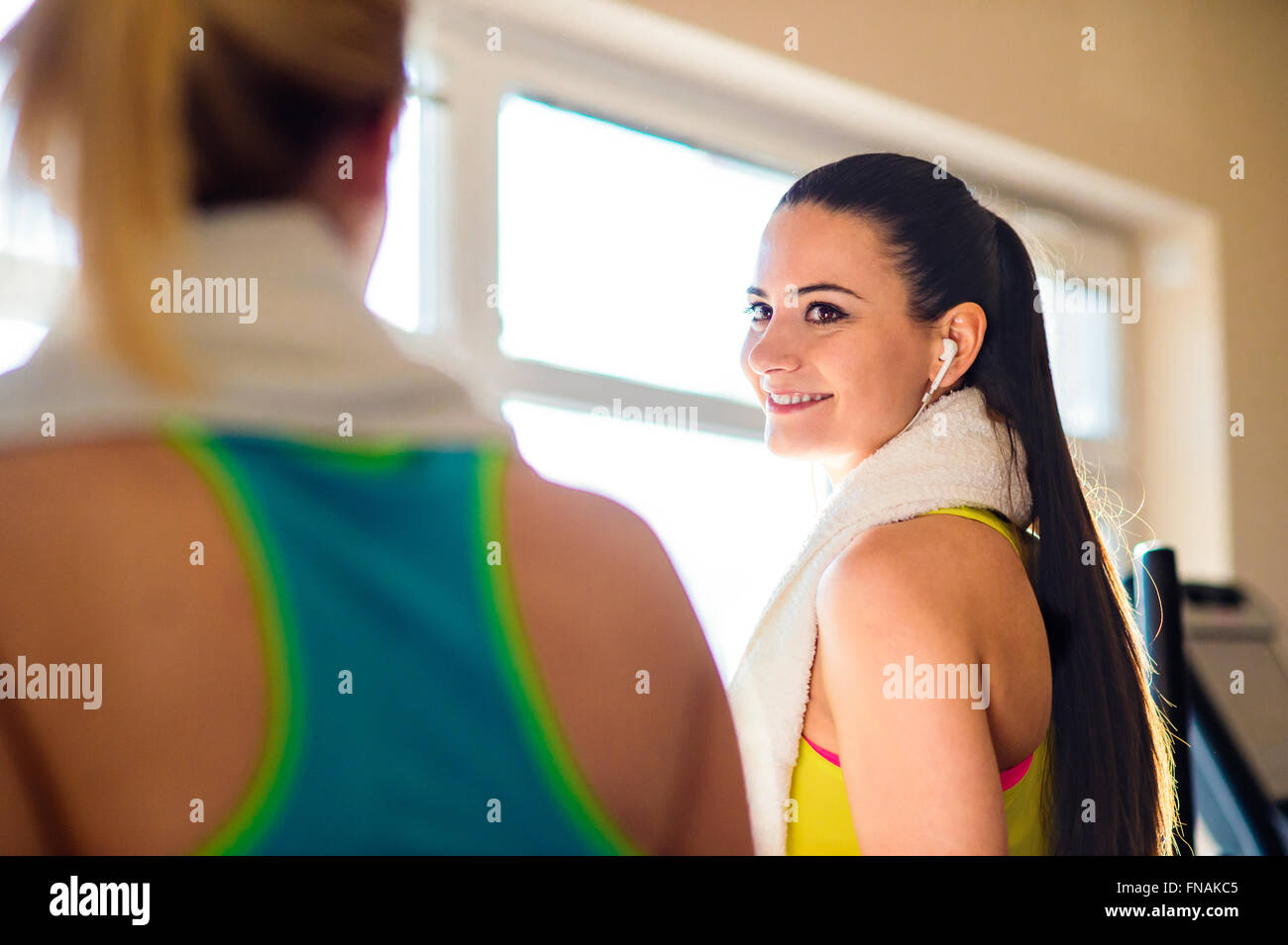 Women in gym with towels around neck, back view Stock Photo - Alamy