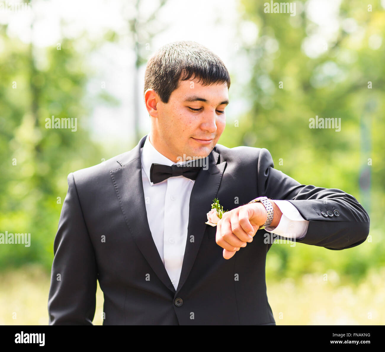 elegant stylish groom waiting his brite and looks at watch Stock Photo ...