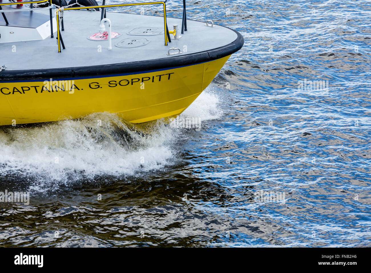 A bright yellow pilot boat speeding across a calm blue harbor Stock ...