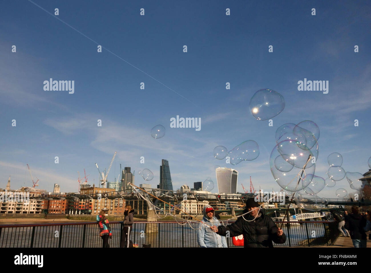 Bubble blowing street entertainer with City of London skyline in ...