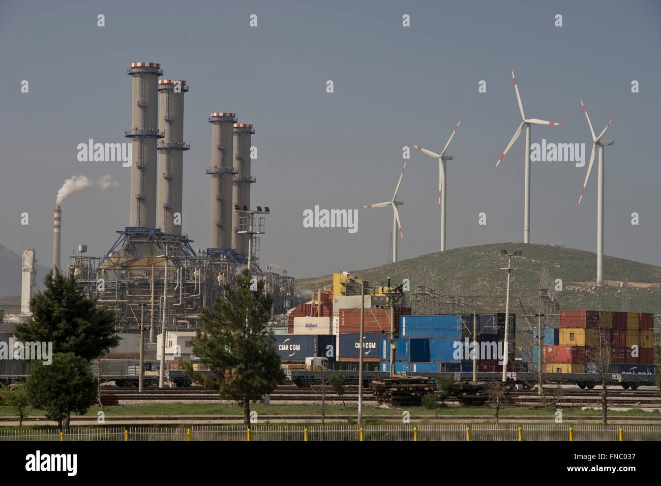 Oil refinery and electricity plant with wind turbines in background ...