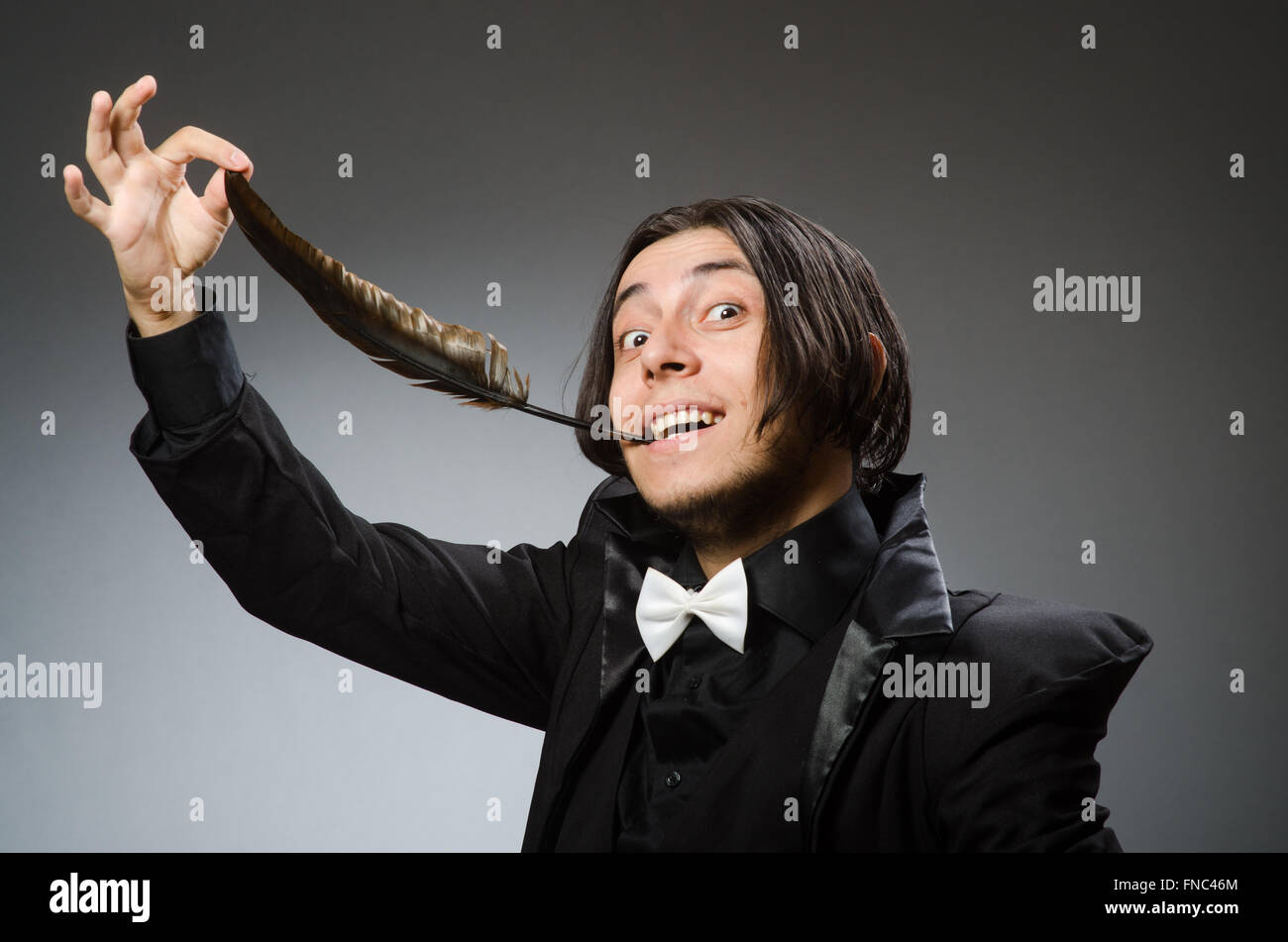 Young man with writing feather Stock Photo - Alamy