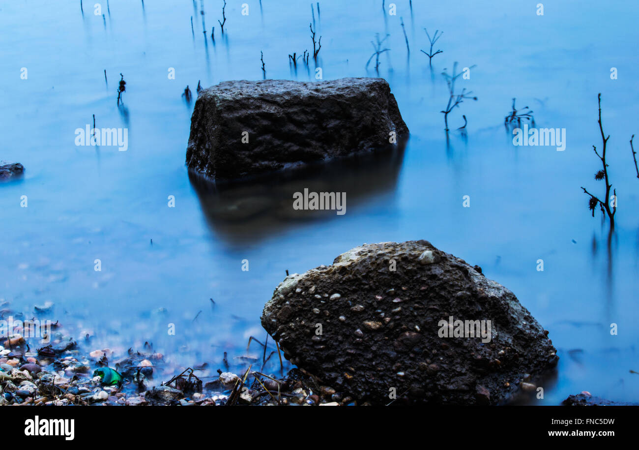 Smoothy water with rock at the background near the beach Stock Photo ...