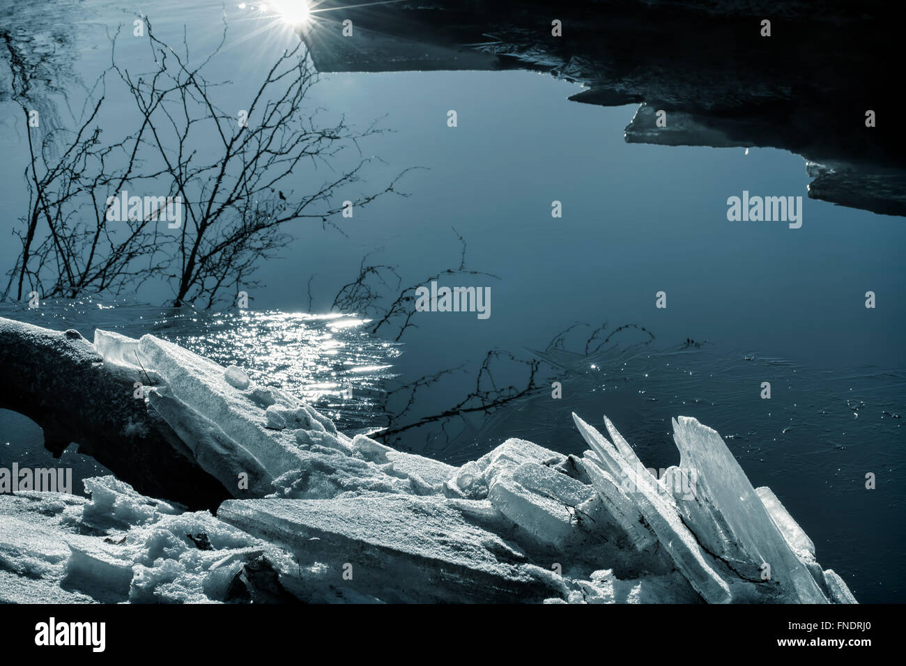 Moonlight shining on ice besides an Alaskan river with reflections and ...