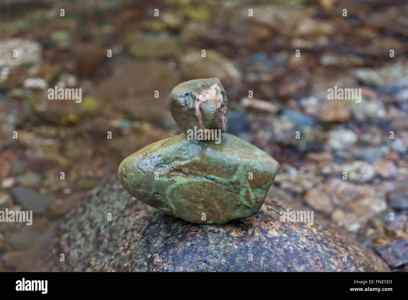Wet stones stacked by the river Stock Photo - Alamy