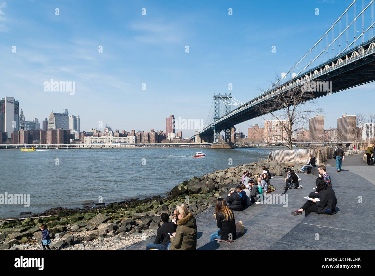 People sitting on the steps in DUMBO, Brooklyn, near the Manhattan ...