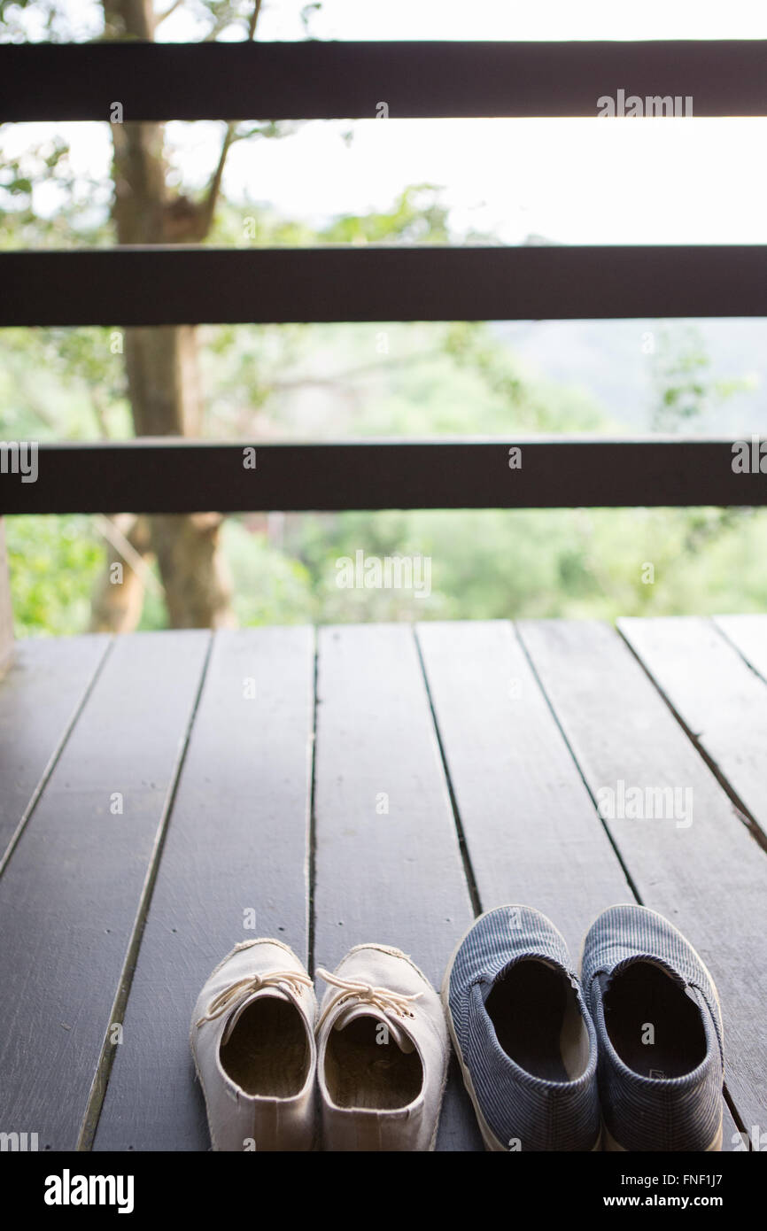 Two pairs of shoes, one woman's and one man's, on a resort balcony ...