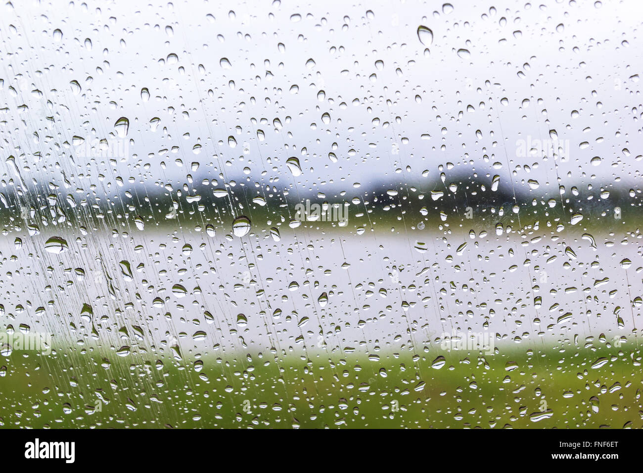 A photo of natural water drops on window glass with nature background ...