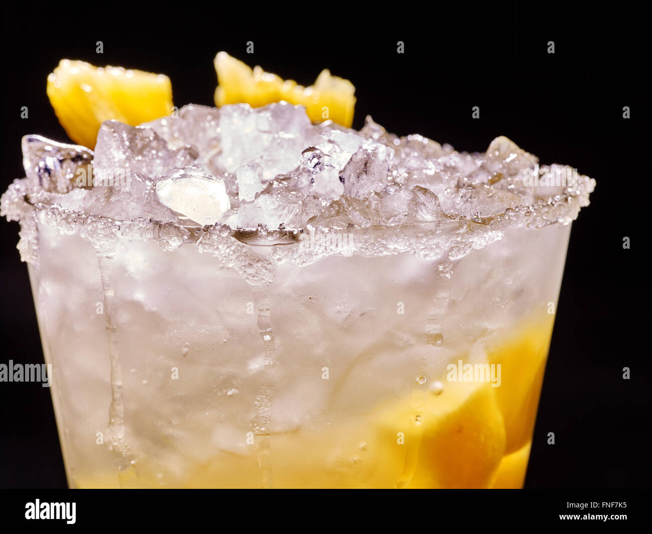 Yellow cube ice of cold drink with pineapple on dark background Stock ...