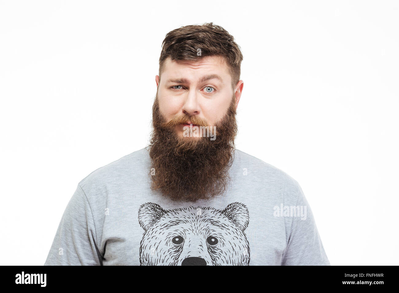 Portrait of confused handsome man with beard looking at camera over ...
