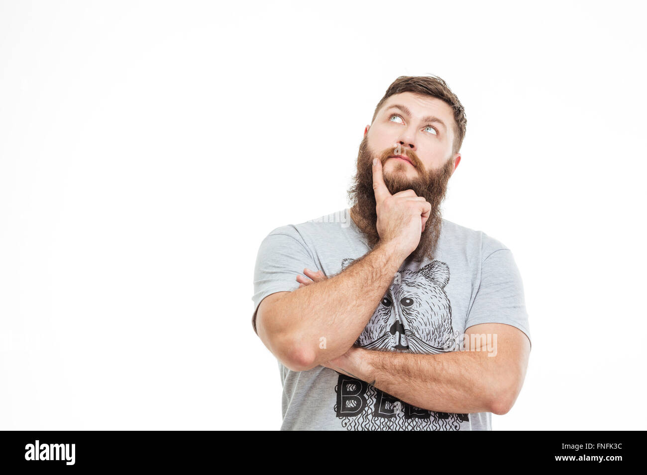 Thoughtful attractive bearded man looking up and thinking over white ...