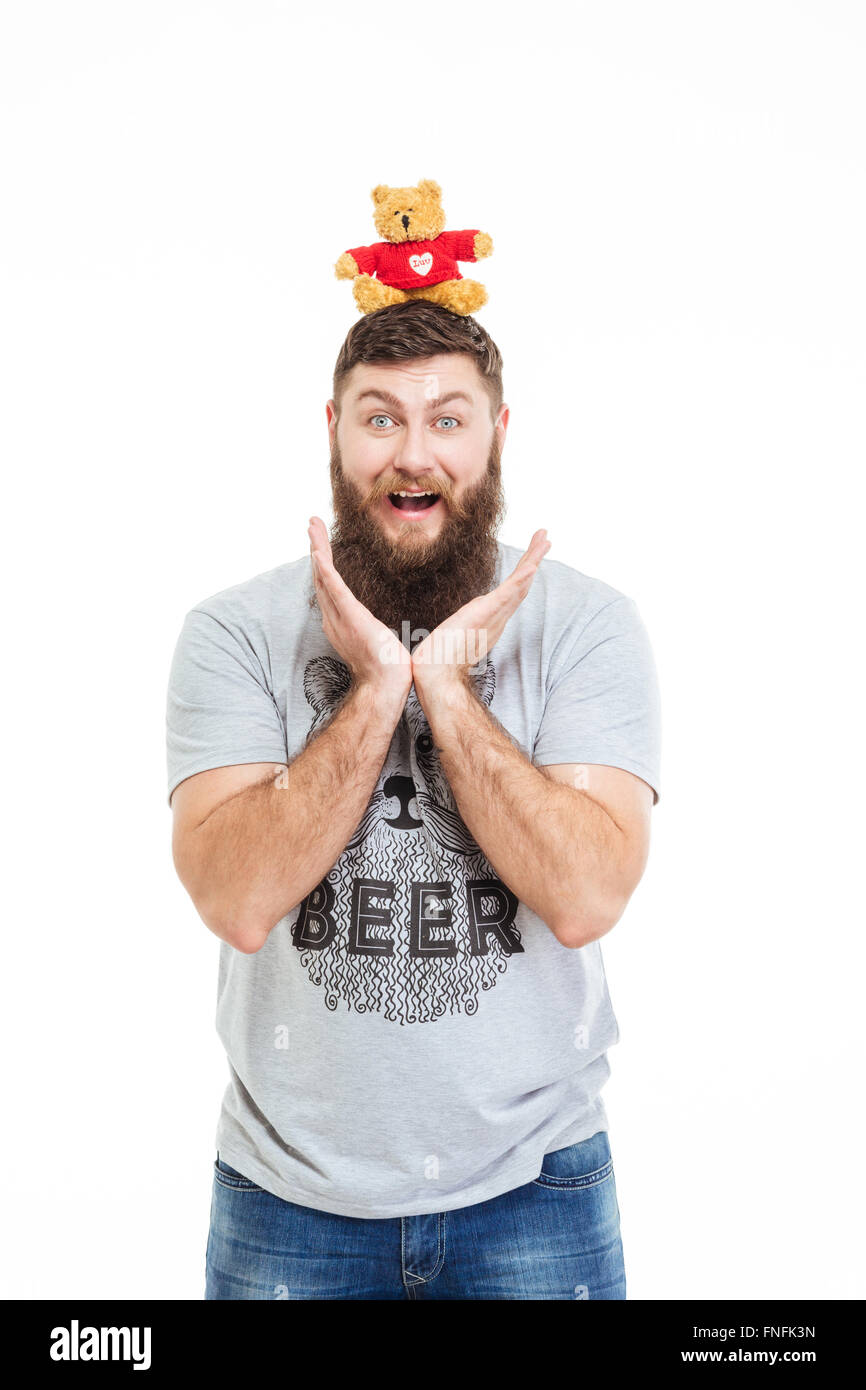 Cheerful funny man with beard put teddy bear on his head over white ...
