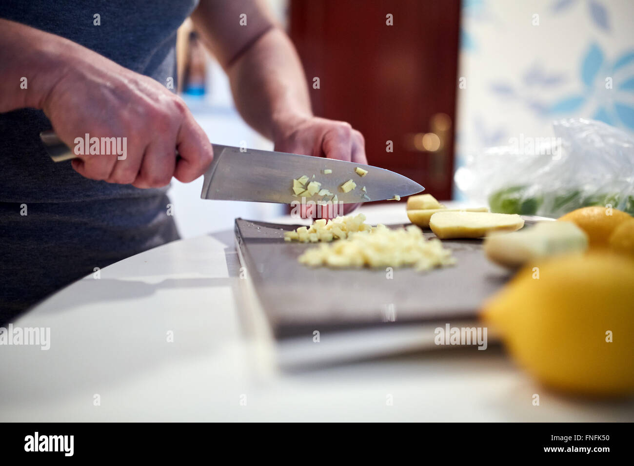 Man cooking at home, chopping ginger for a recipe Stock Photo - Alamy