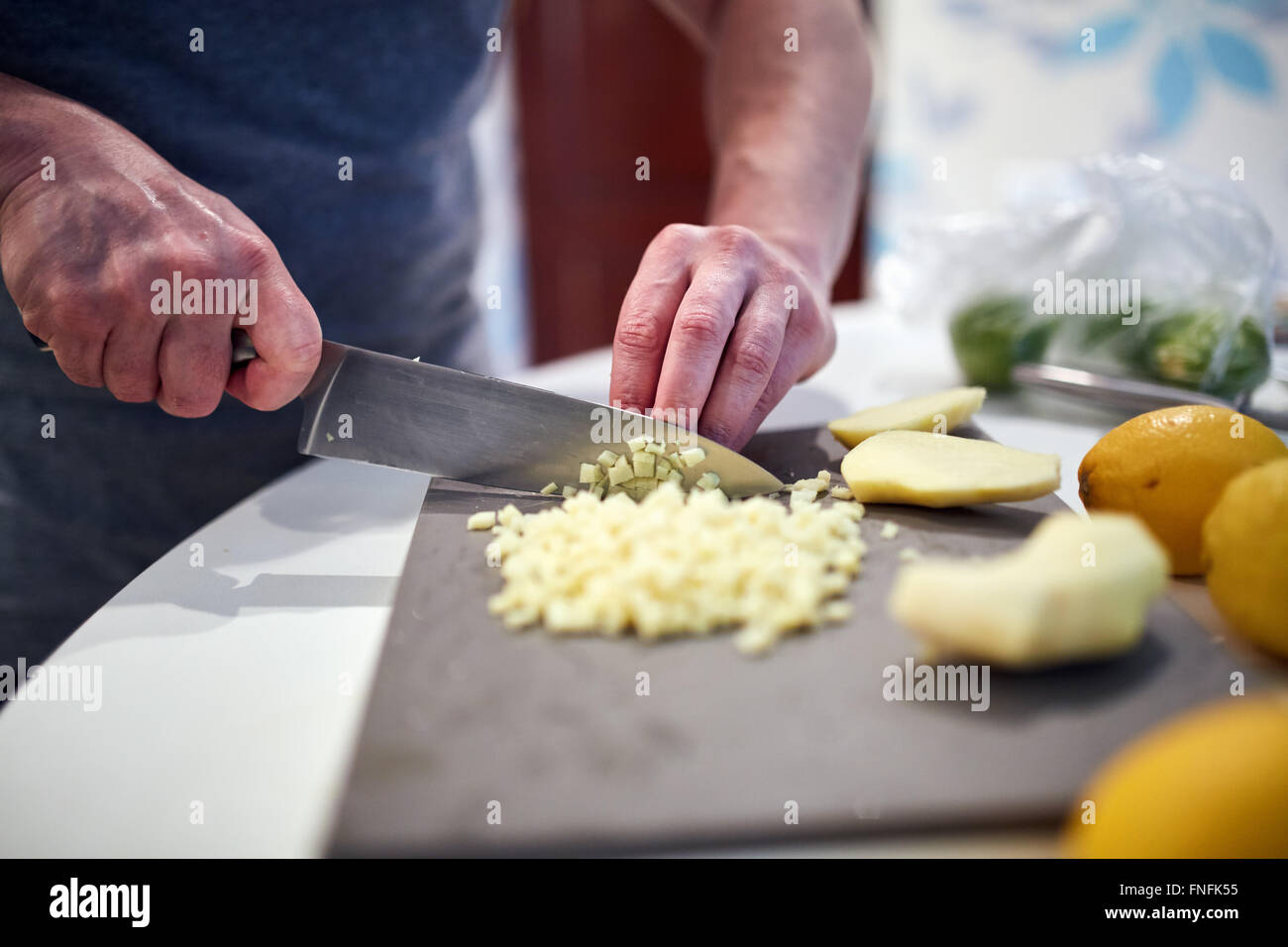 Man cooking at home, chopping ginger for a recipe Stock Photo - Alamy