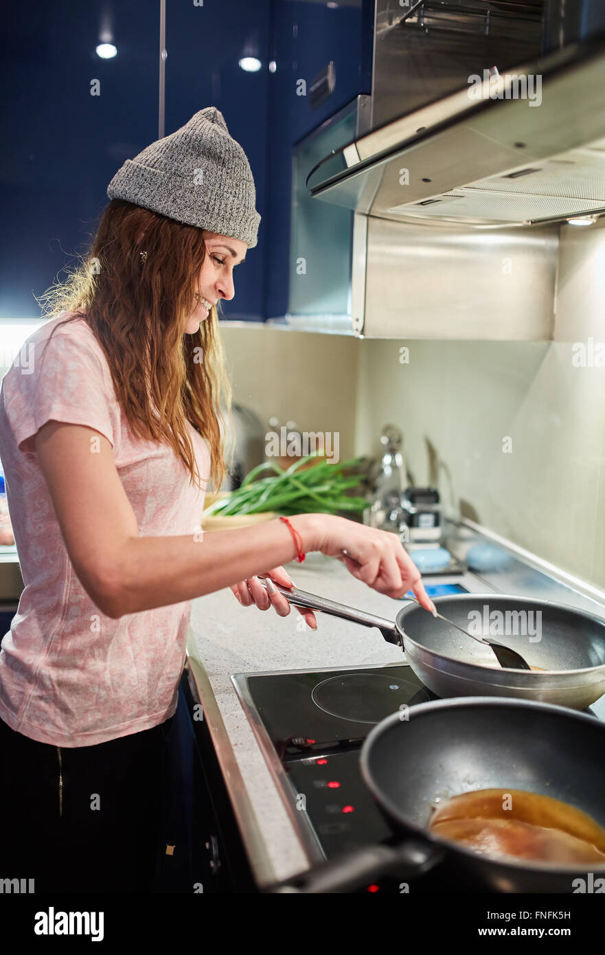 Woman cooking at home with frying pans on the stove Stock Photo - Alamy