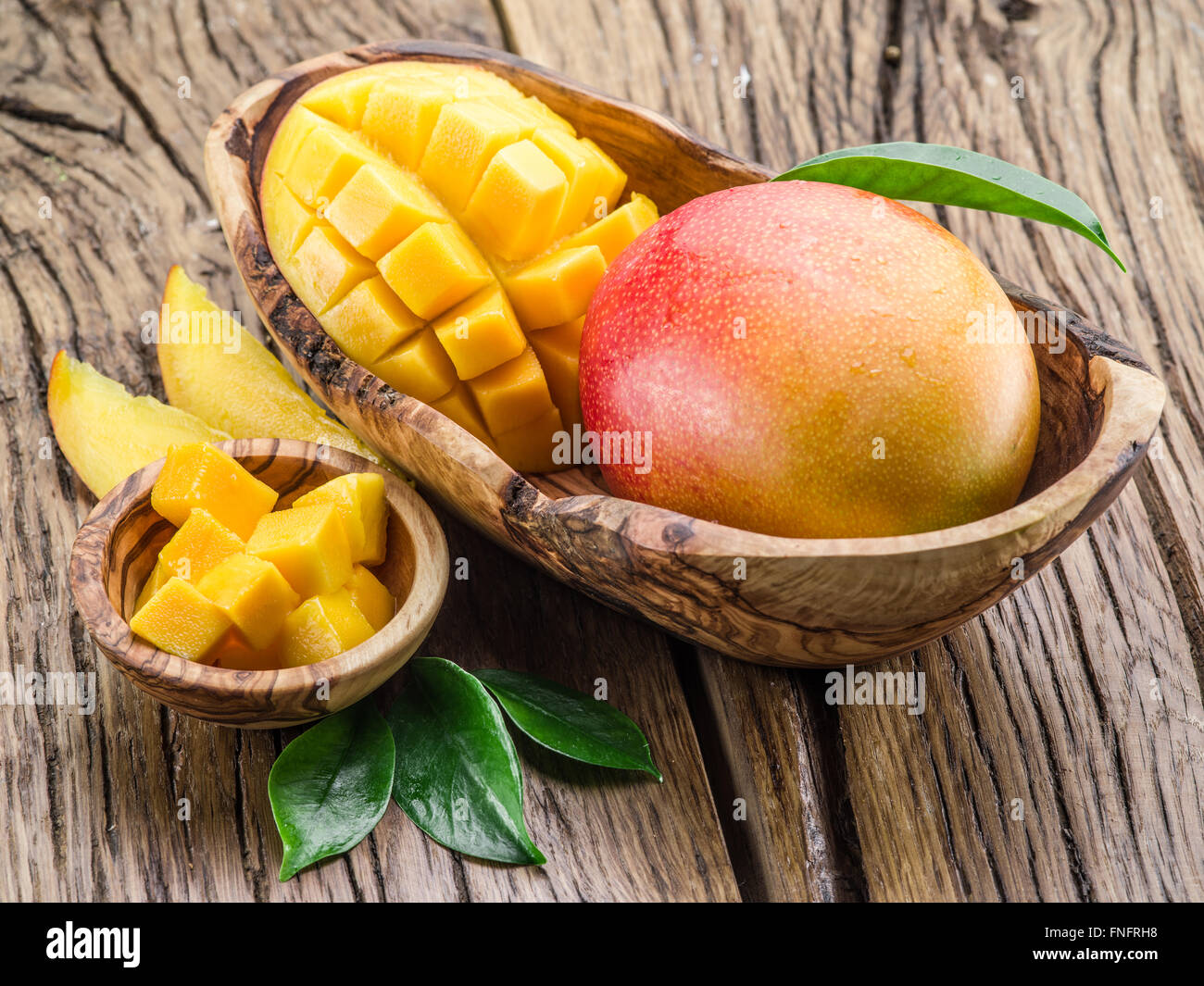 Mango fruit and mango cubes on the wooden table Stock Photo - Alamy