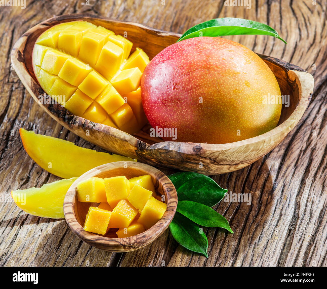 Mango fruit and mango cubes on the wooden table Stock Photo - Alamy