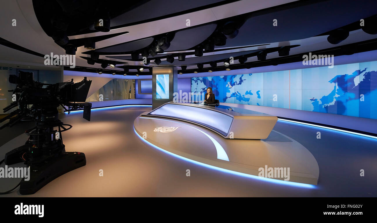 View of news studio with presenter on-air with silhouetted camera. Al ...