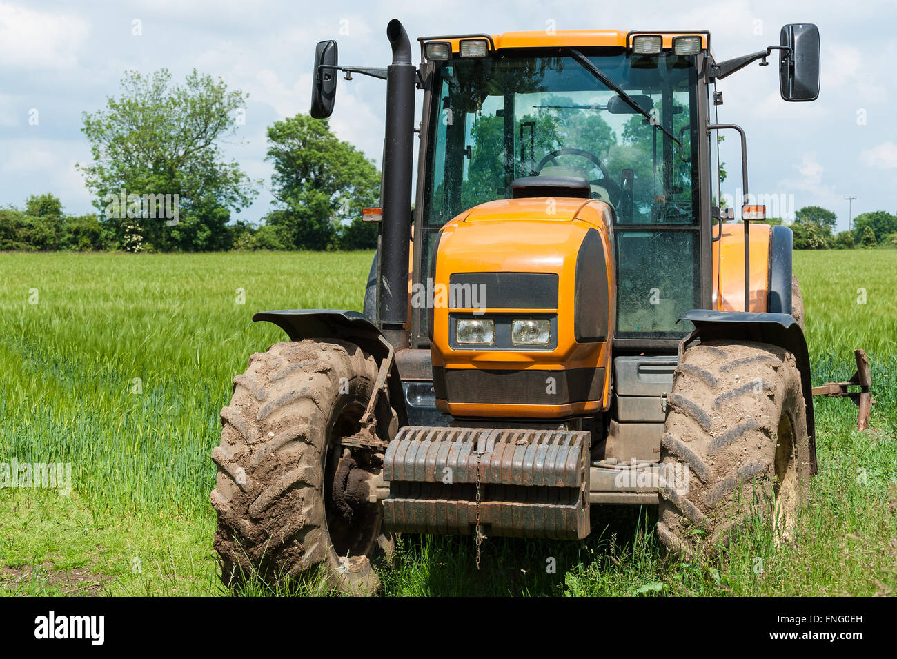 Tractor with muddy wheels in field Stock Photo - Alamy
