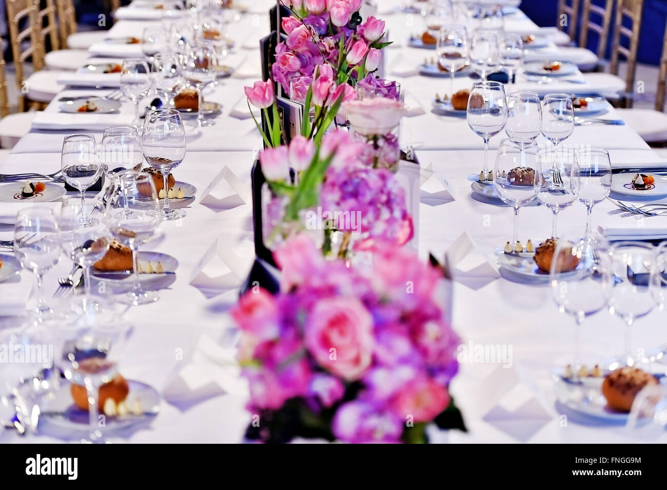 Festive dinner table with flowers bouquets and starters inside a ...