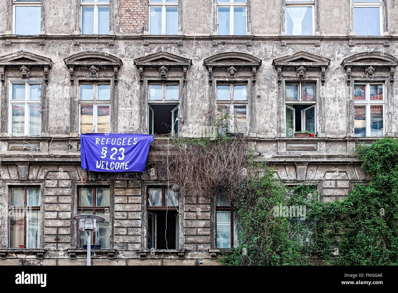 Refugees Welcome banner on derelict old apartment building in Berlin ...