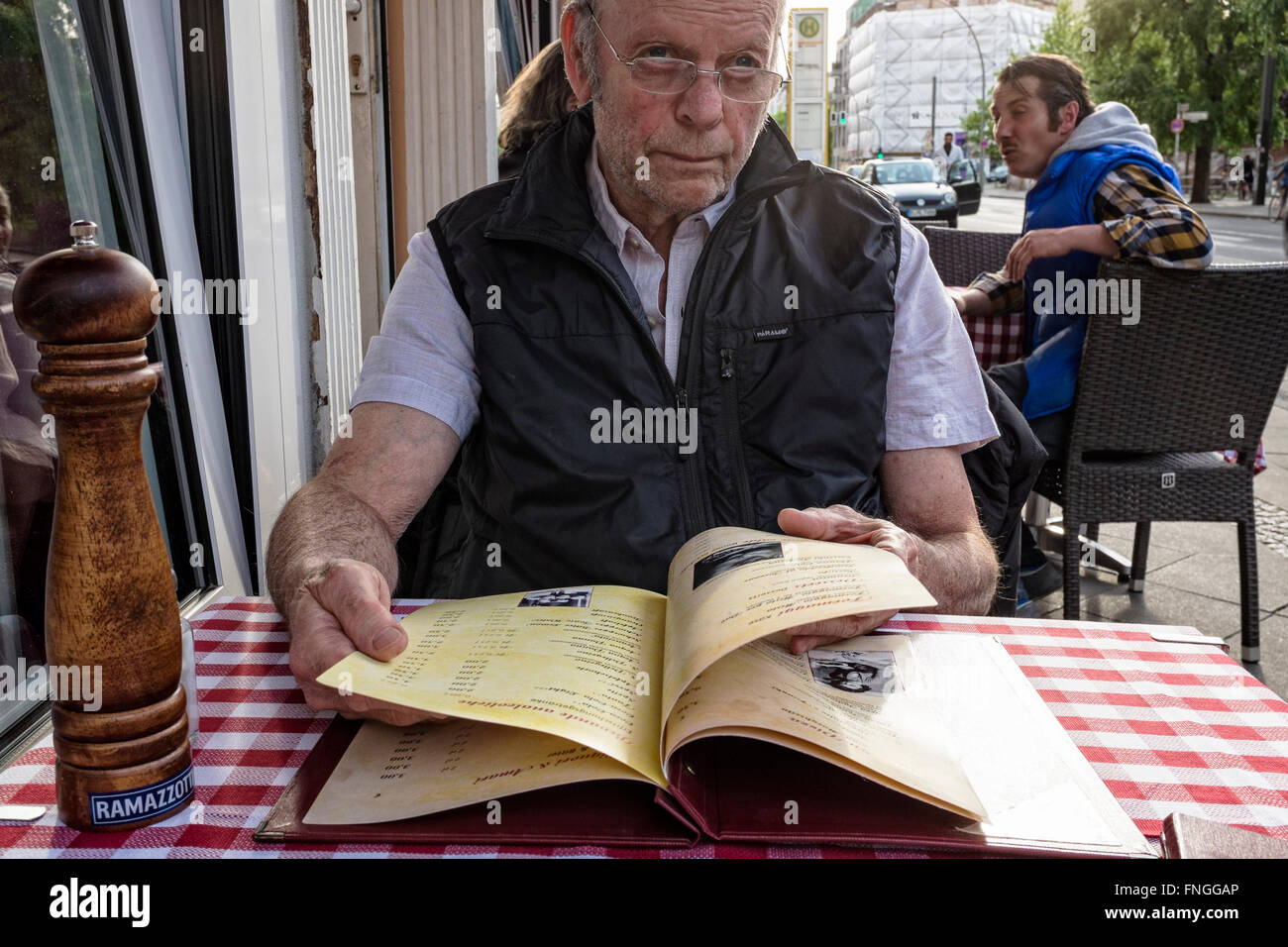 Senior man reading menu at pavement table of restaurant, Berlin Stock ...