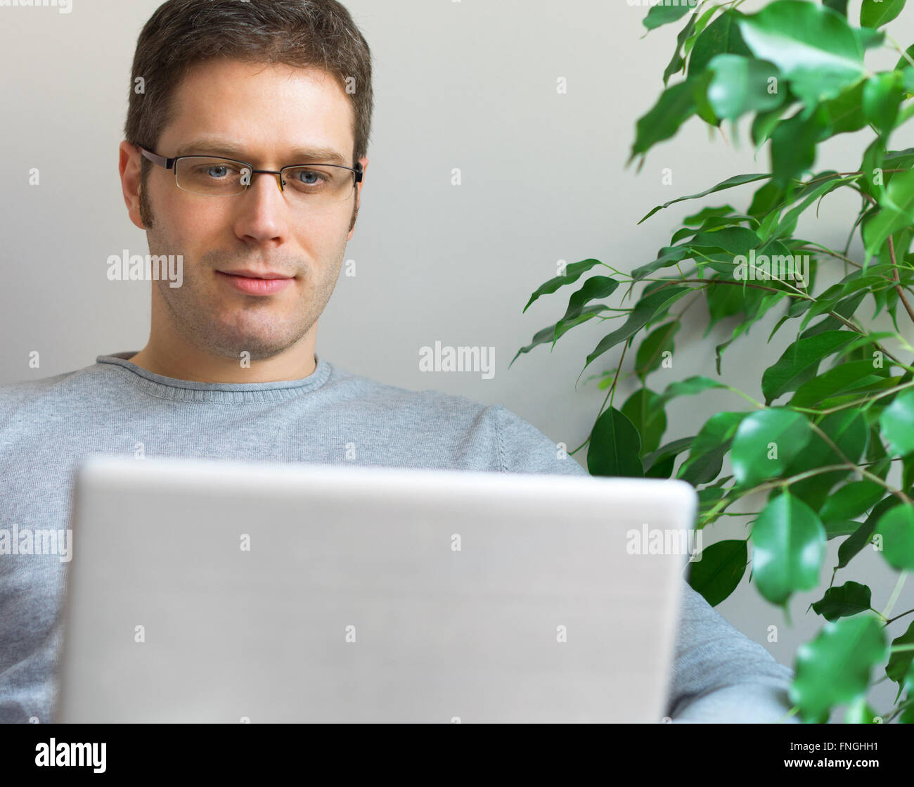 Man relaxing with laptop computer on the sofa Stock Photo - Alamy