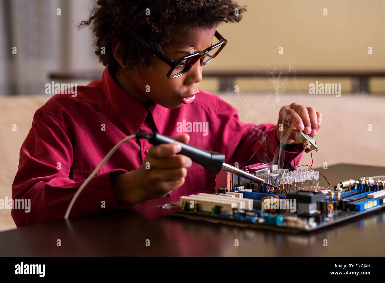 Surprised black boy fixing motherboard Stock Photo - Alamy