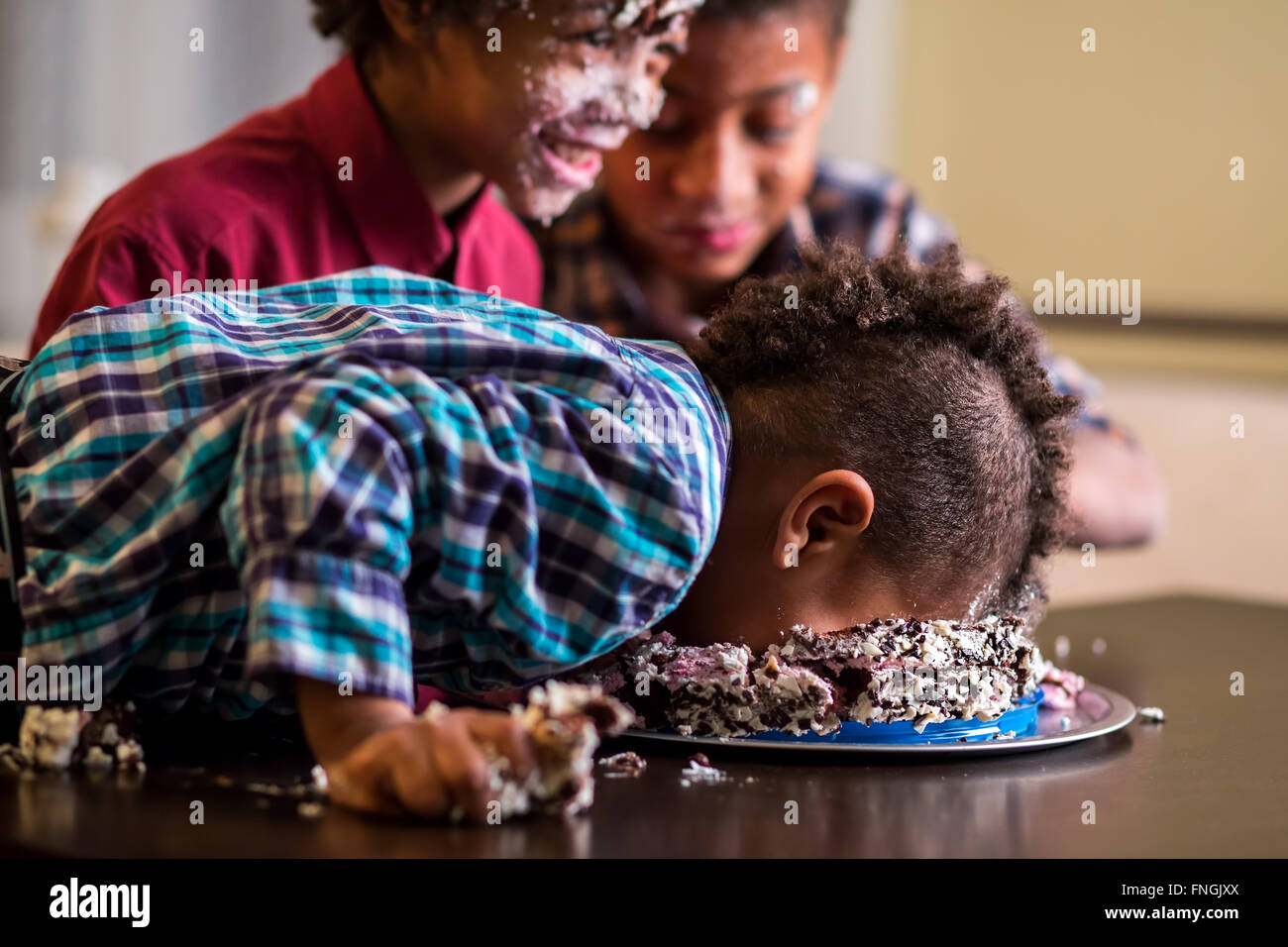 Afro boy's face smashing cake Stock Photo - Alamy