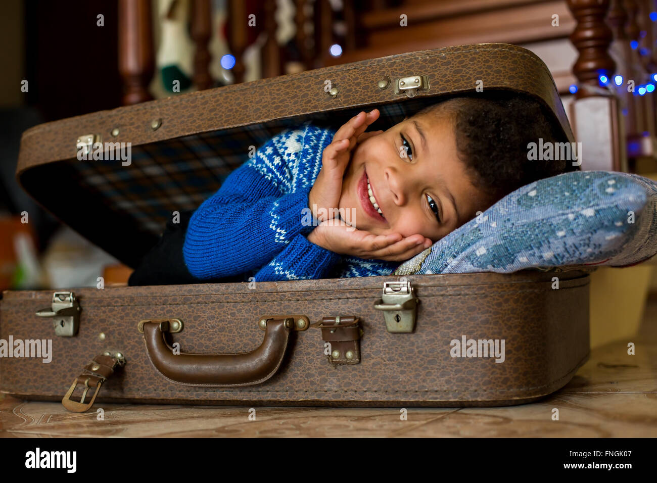 Smiling kid laying inside suitcase Stock Photo - Alamy
