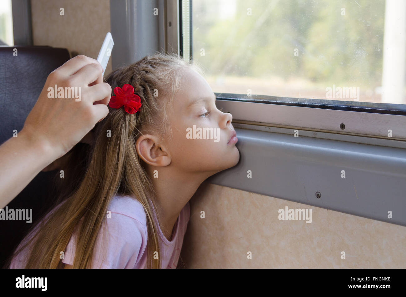 sad six year old girl looking in the window while sitting in an ...