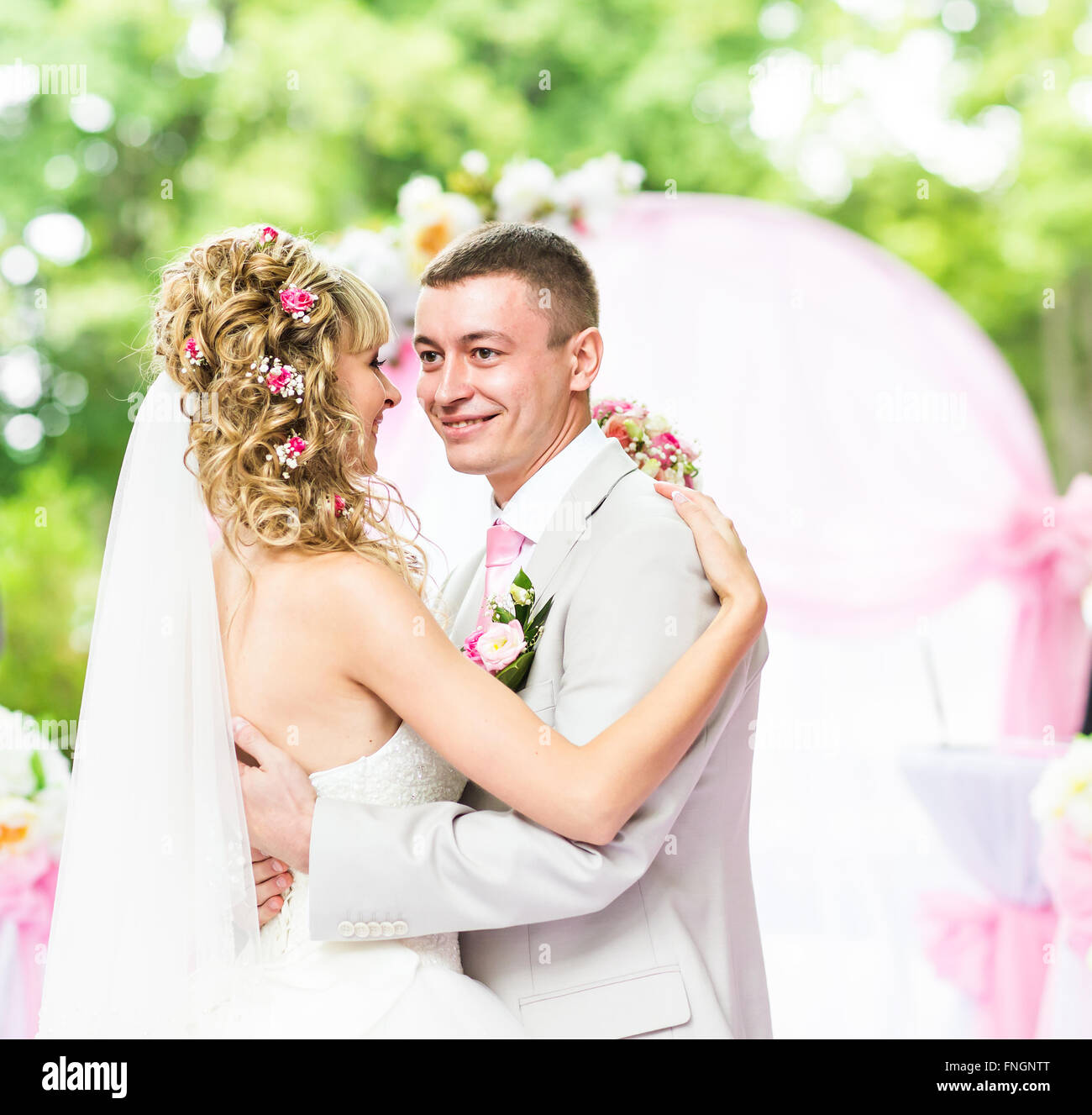 Happy newlywed romantic couple dancing at wedding aisle with pink ...
