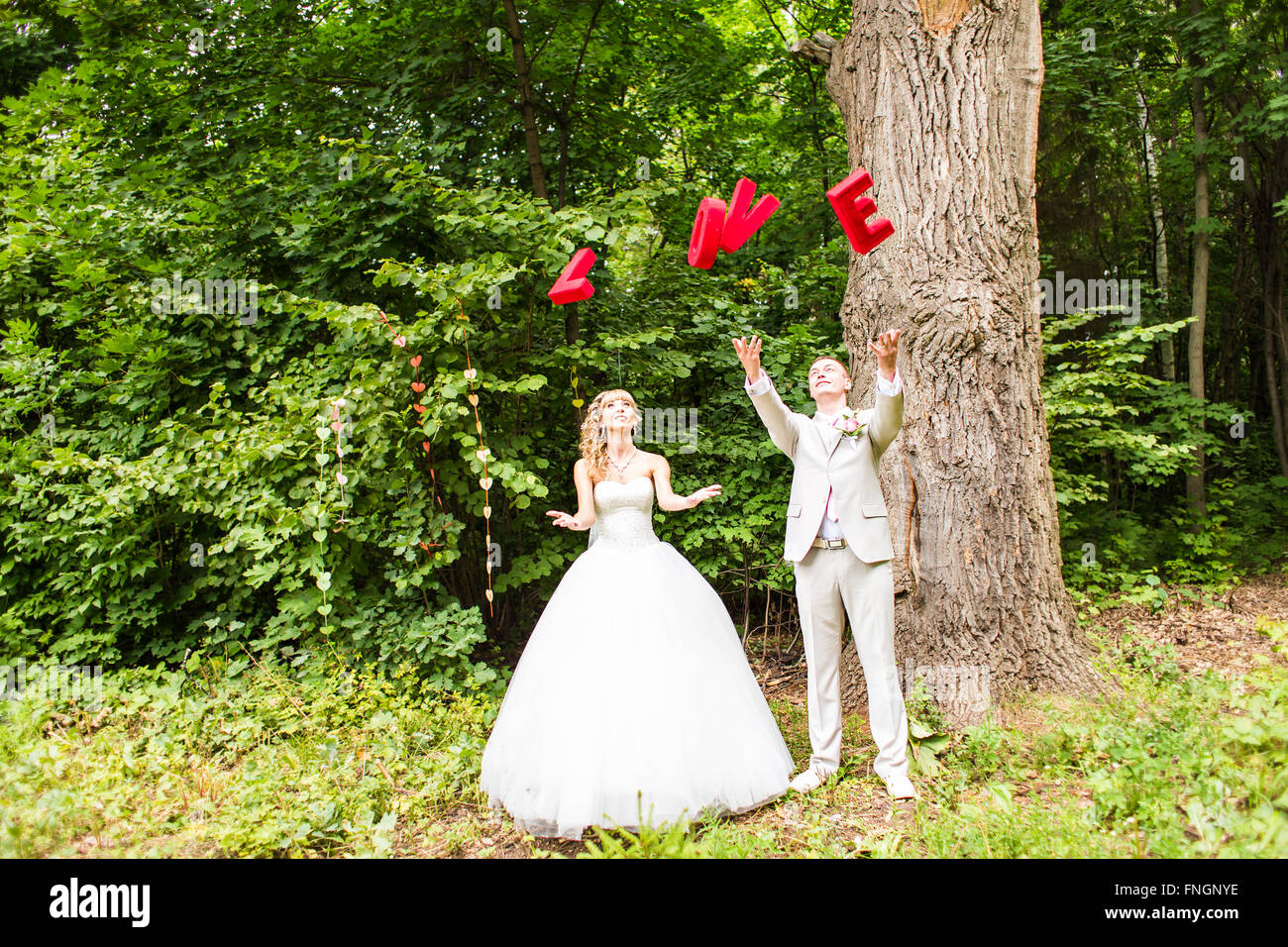 Bride and groom holding the letter word love Stock Photo - Alamy