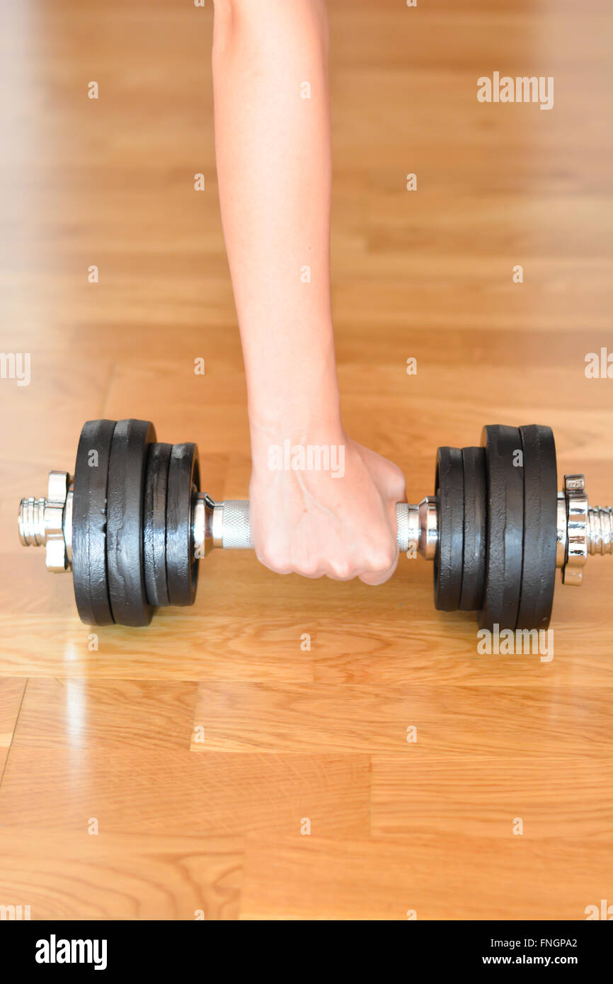 Woman pumping up muscles Lifting Dumbbell at home Stock Photo - Alamy